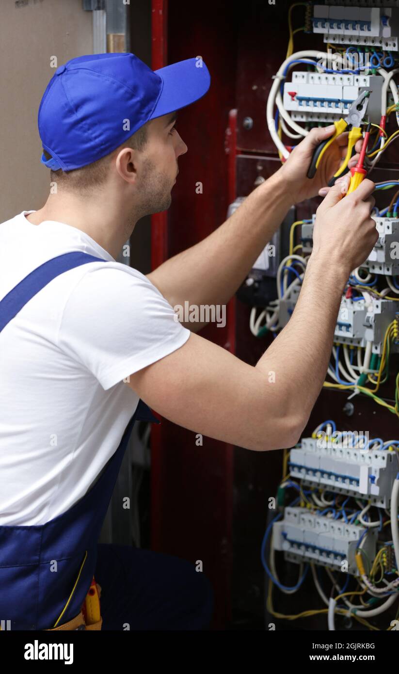 Electrician connecting wires in distribution board Stock Photo - Alamy