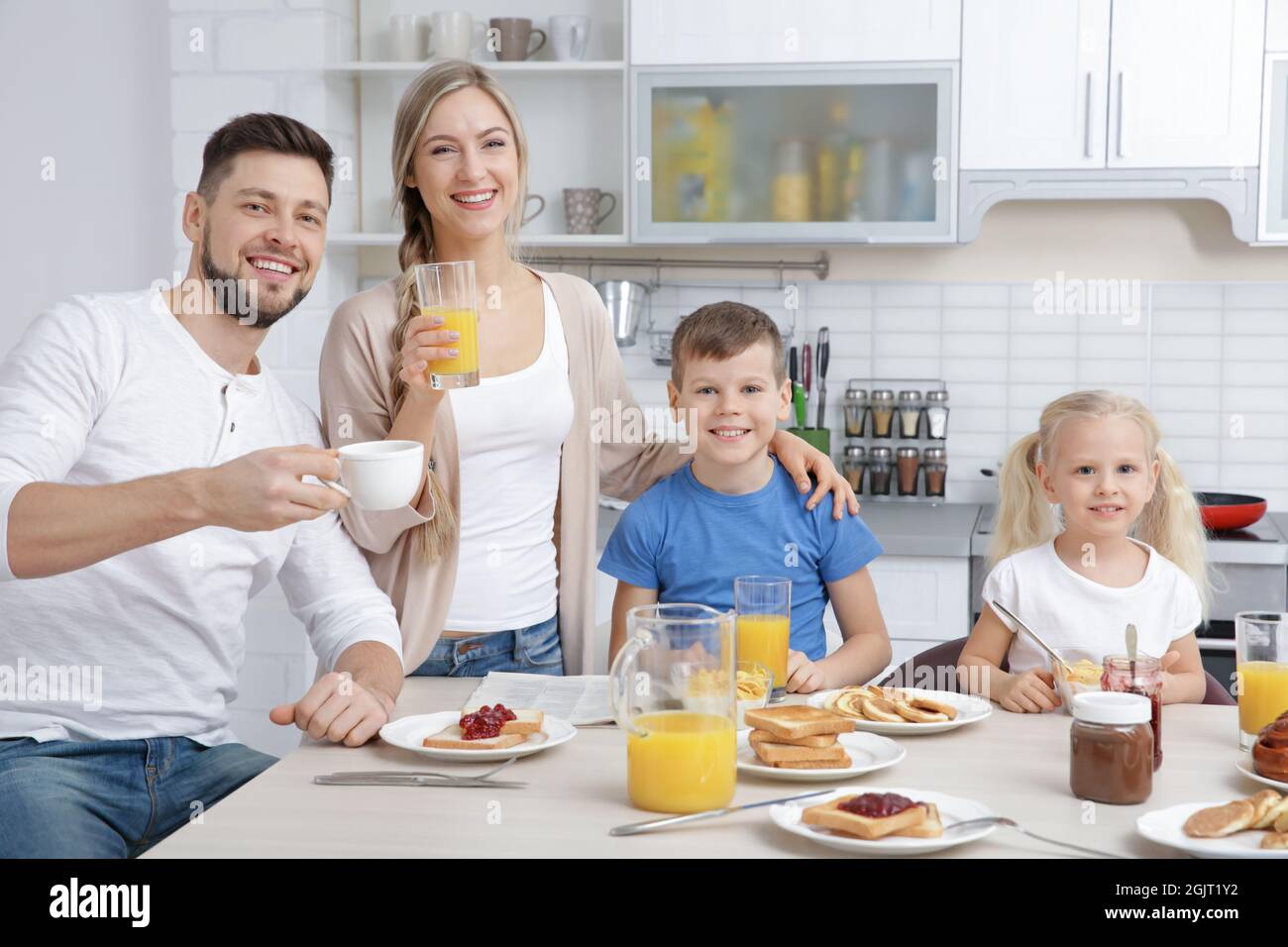Happy family having breakfast on kitchen Stock Photo - Alamy