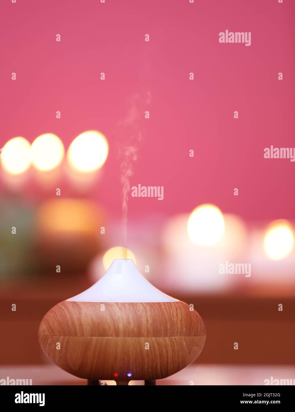 Aroma oil diffuser on blurred candlelight background Stock Photo - Alamy