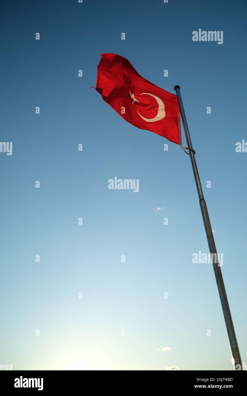 A Turkish flag waving on a blue sky background Stock Photo - Alamy