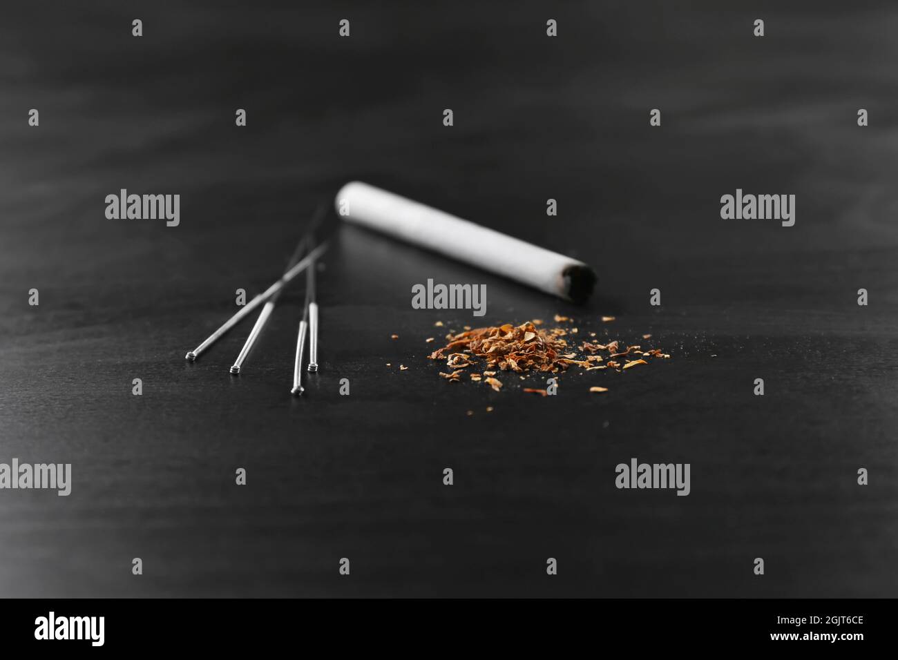 Acupuncture needles with cigarette on dark background Stock Photo - Alamy