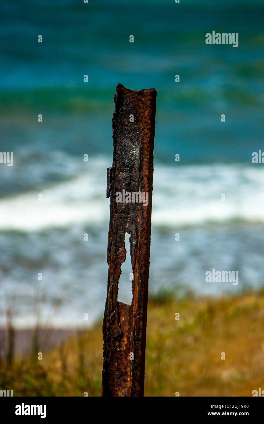 Rusted metal fence post with a coastal background Stock Photo - Alamy