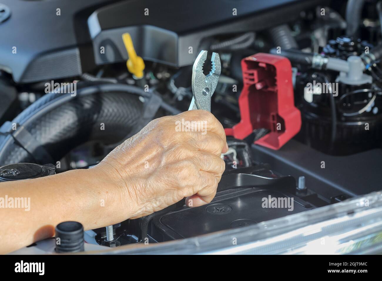 Elderly woman repairing her car Stock Photo - Alamy