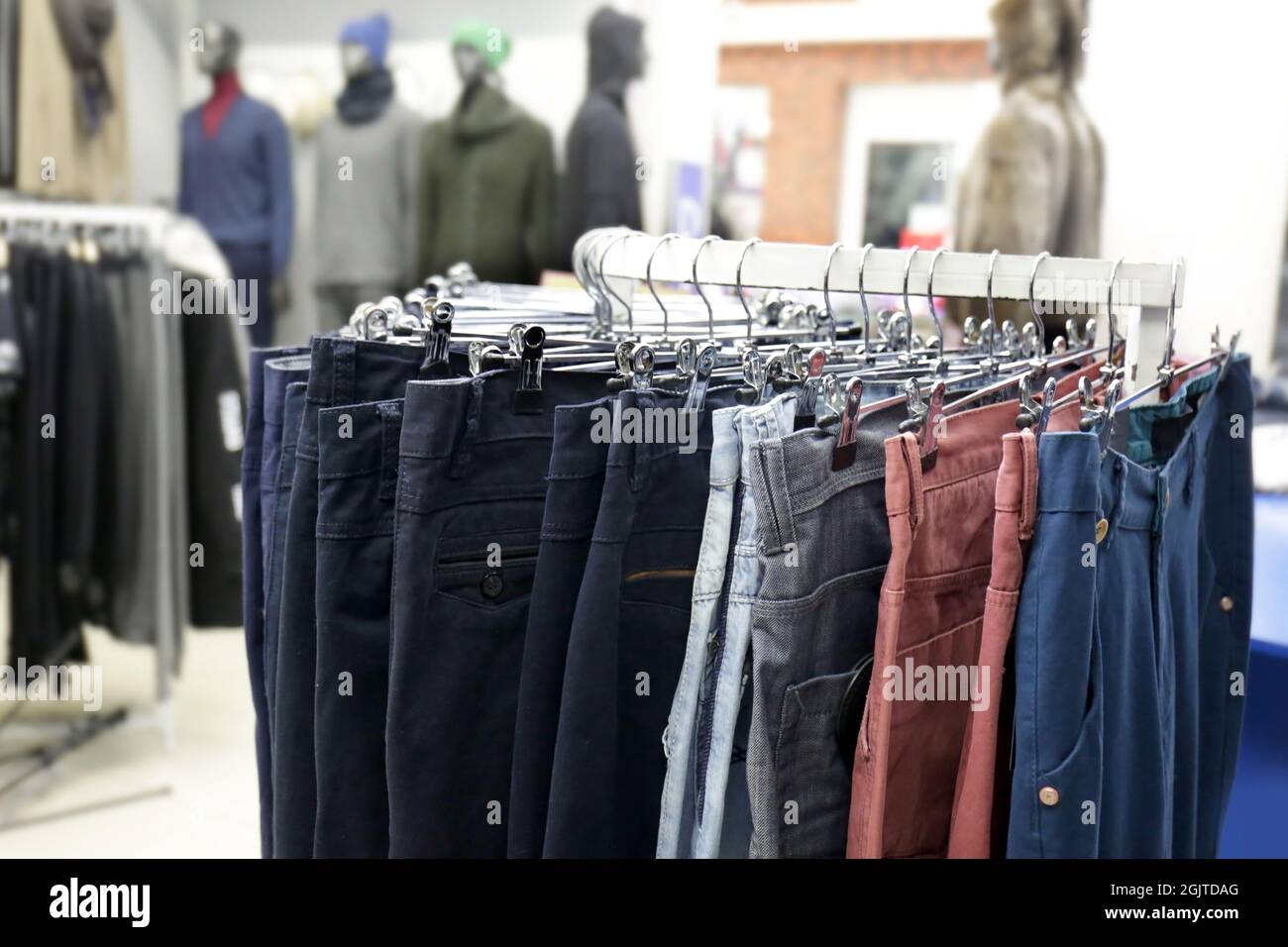 Rack with pants in modern shop Stock Photo - Alamy