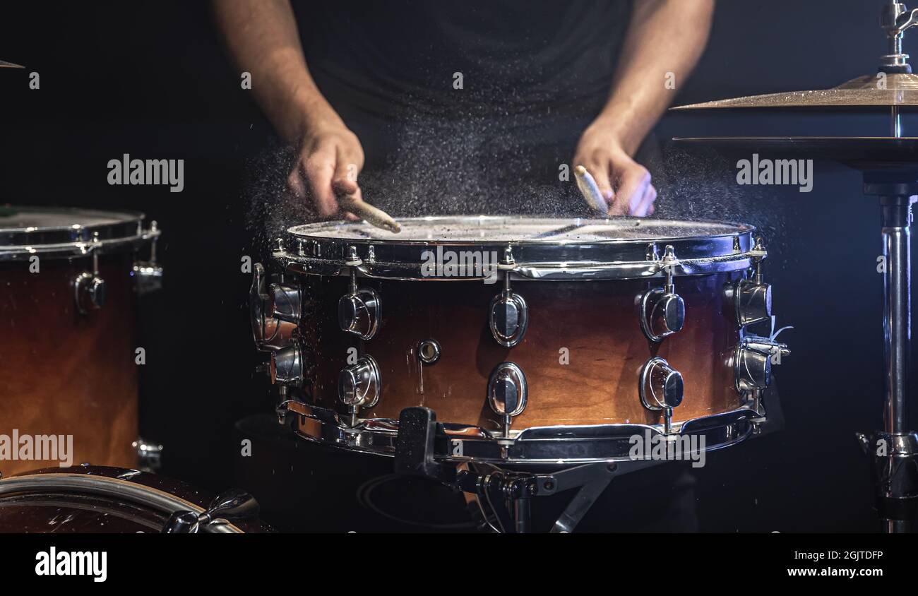 A male drummer plays snare drum with drumsticks in a dark room Stock ...