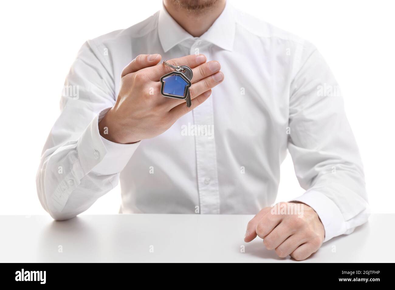 Man holding house key in hand on white background Stock Photo - Alamy