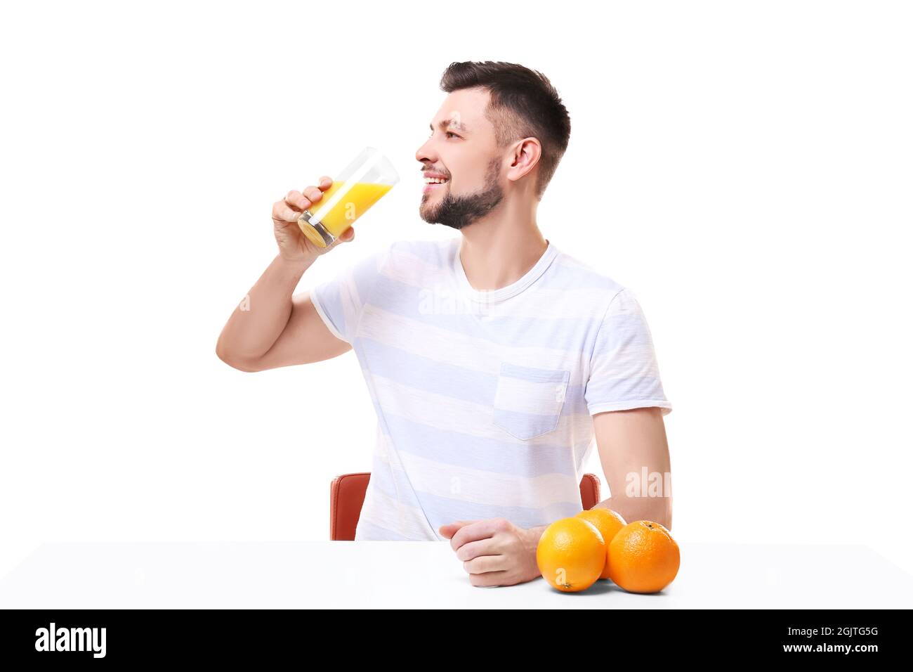 Handsome man posing with juice on white background Stock Photo - Alamy