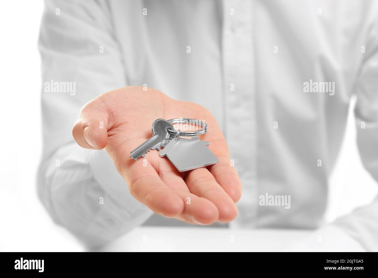 Man holding house key in hand on white background Stock Photo - Alamy