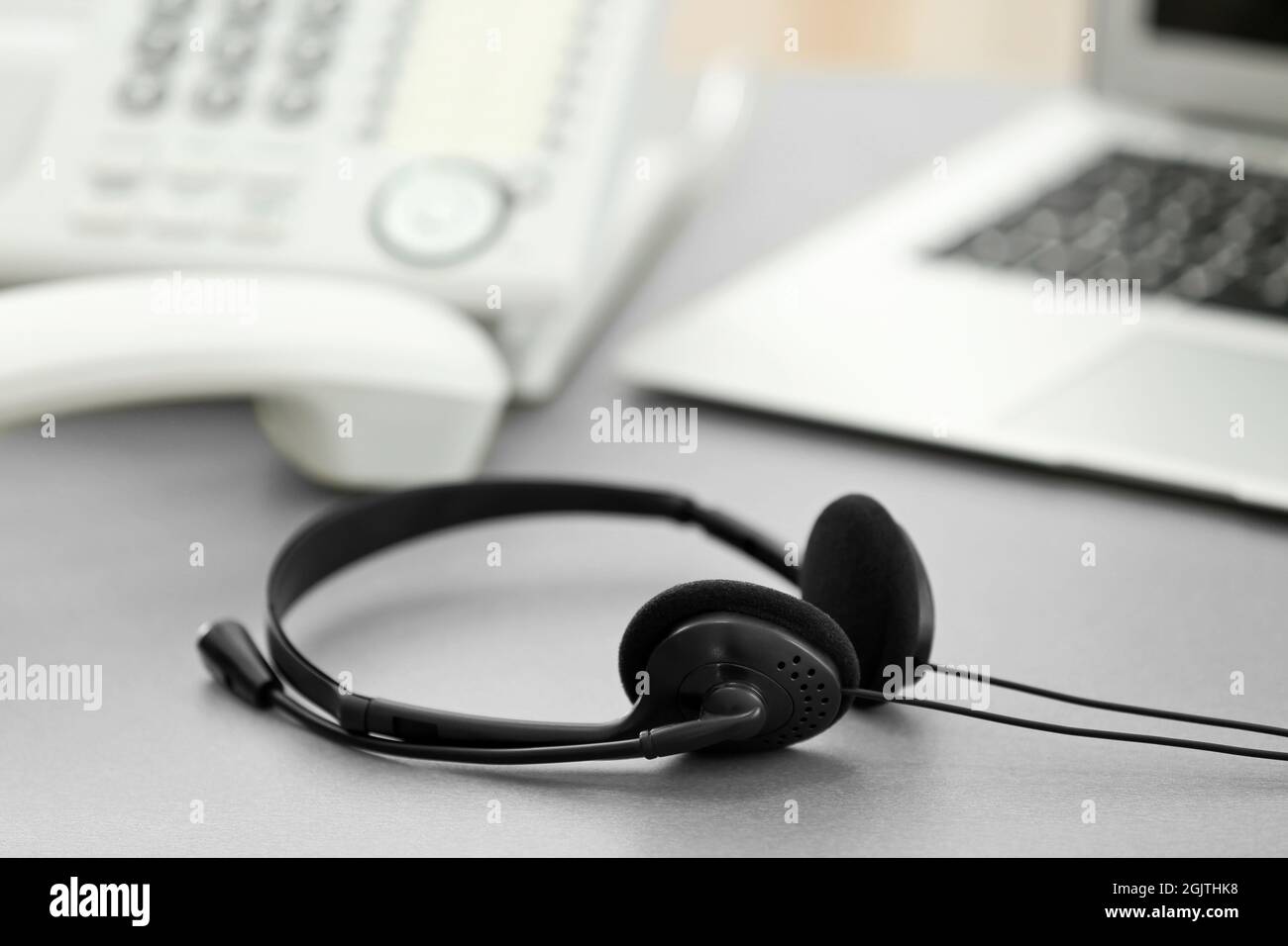 Headset on table of technical support agent in office Stock Photo - Alamy