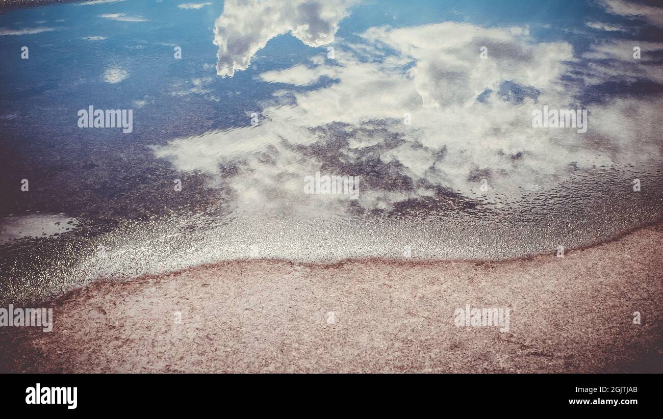 The blue color of the sky reflect in the water on the street after rain ...