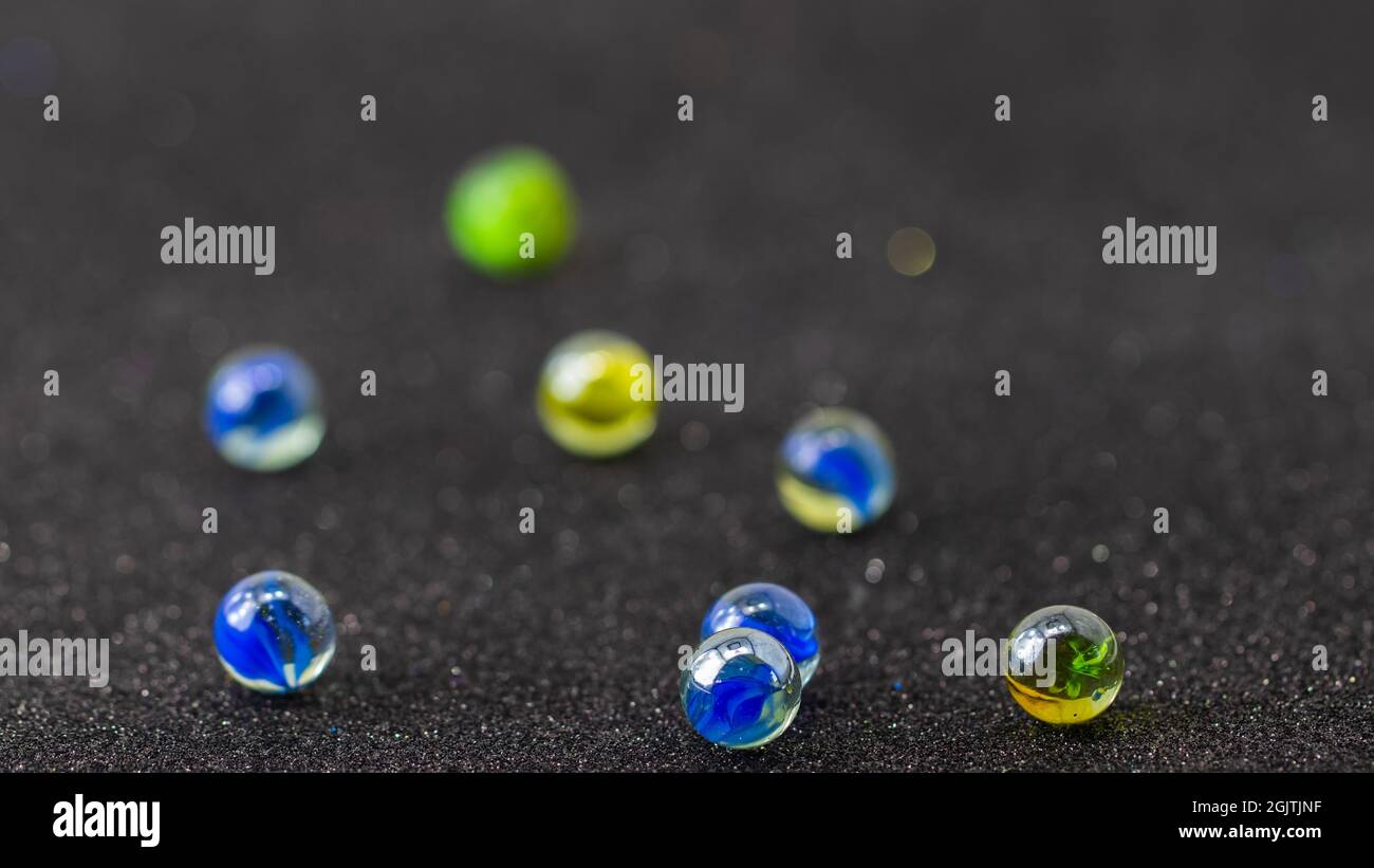coloured glass marbles scattered on black background Stock Photo - Alamy