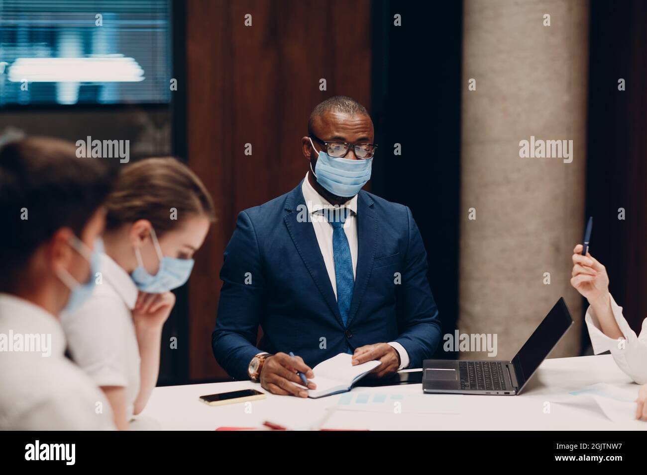 Colleagues diverse team wearing face mask office meeting. Businessmen ...