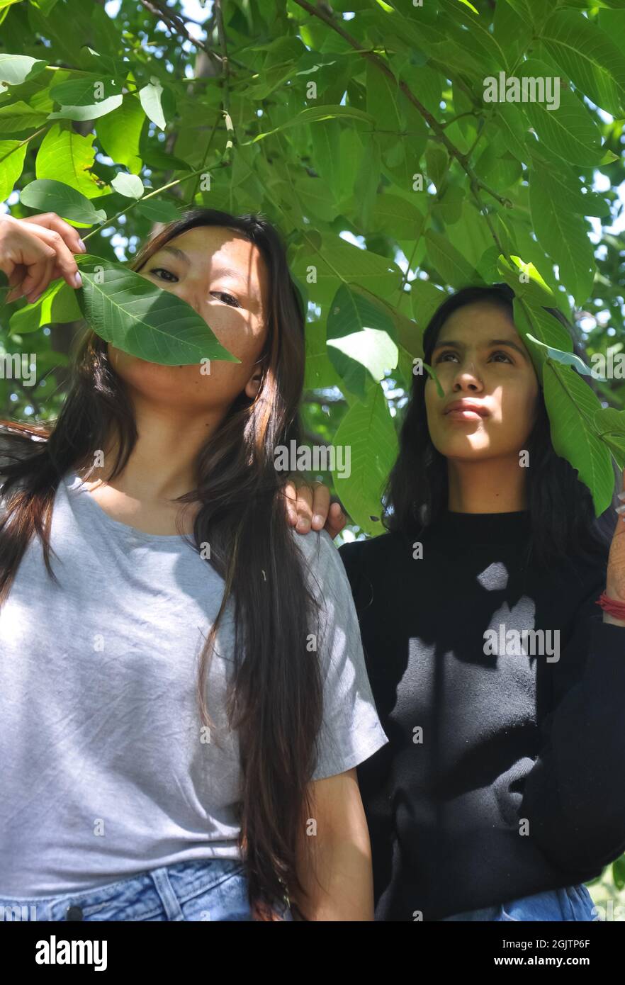 Low angle view of two beautiful south asian young girls posing outside ...