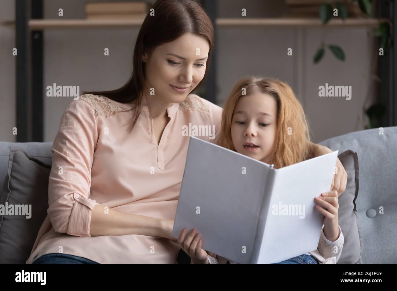 Happy family reading paper book at home Stock Photo - Alamy