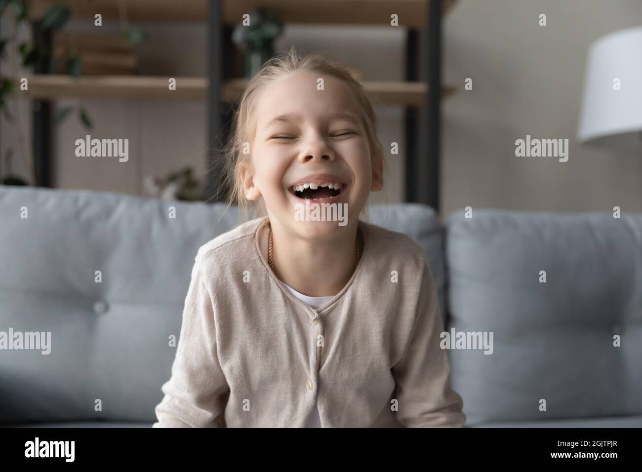 Overjoyed adorable small child girl laughing, showing sincere emotions ...