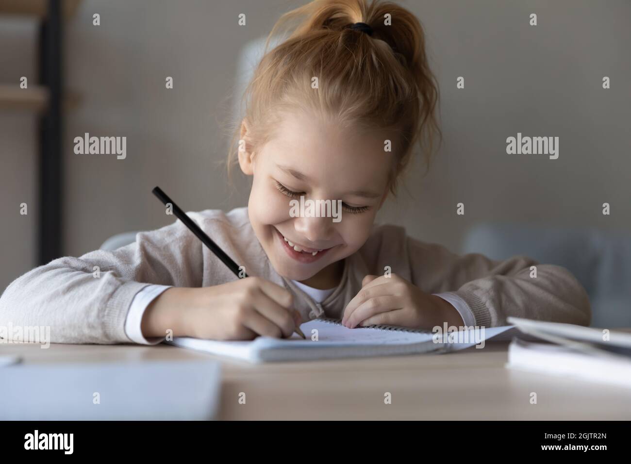Sincere happy small redhead child girl studying at home Stock Photo - Alamy