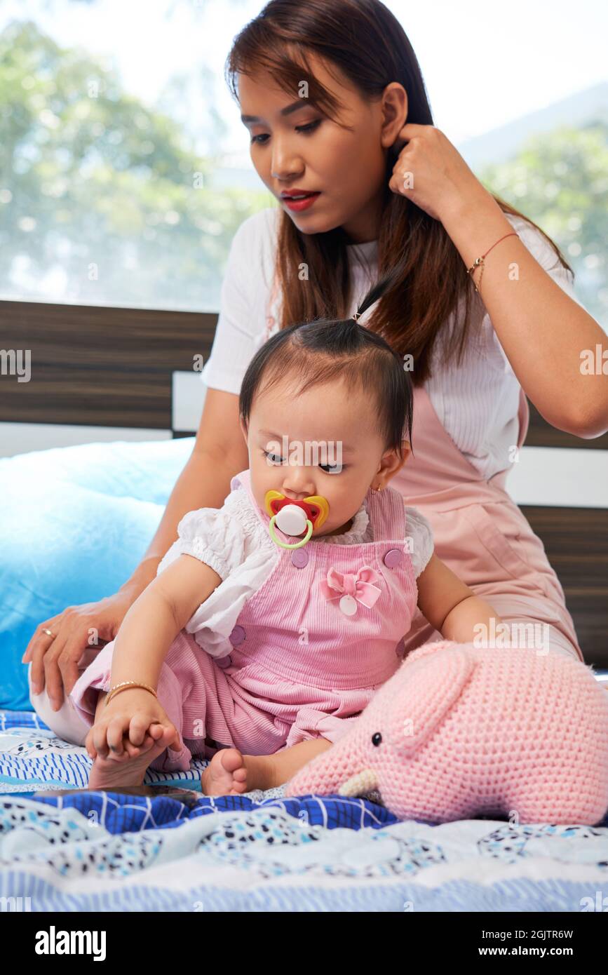 Baby sitting on bed hi-res stock photography and images - Alamy