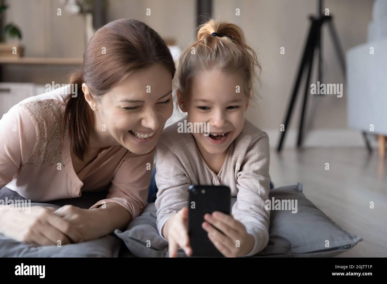 Happy two generations family using cellphone at home Stock Photo - Alamy