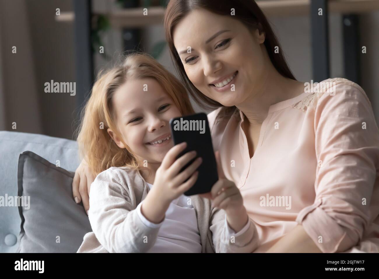 Happy small kid using smartphone with caring mother Stock Photo - Alamy