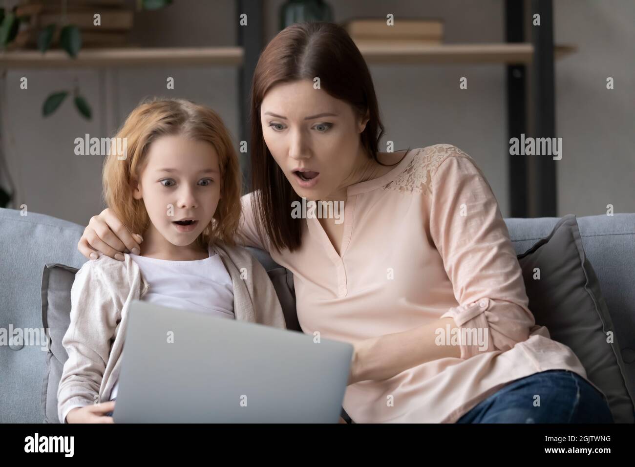 Surprised family looking at laptop screen at home Stock Photo - Alamy
