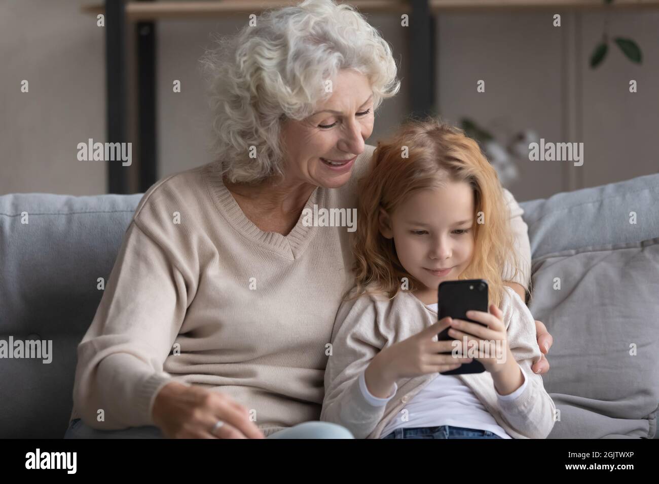 Happy granny and small girl using cellphone Stock Photo - Alamy