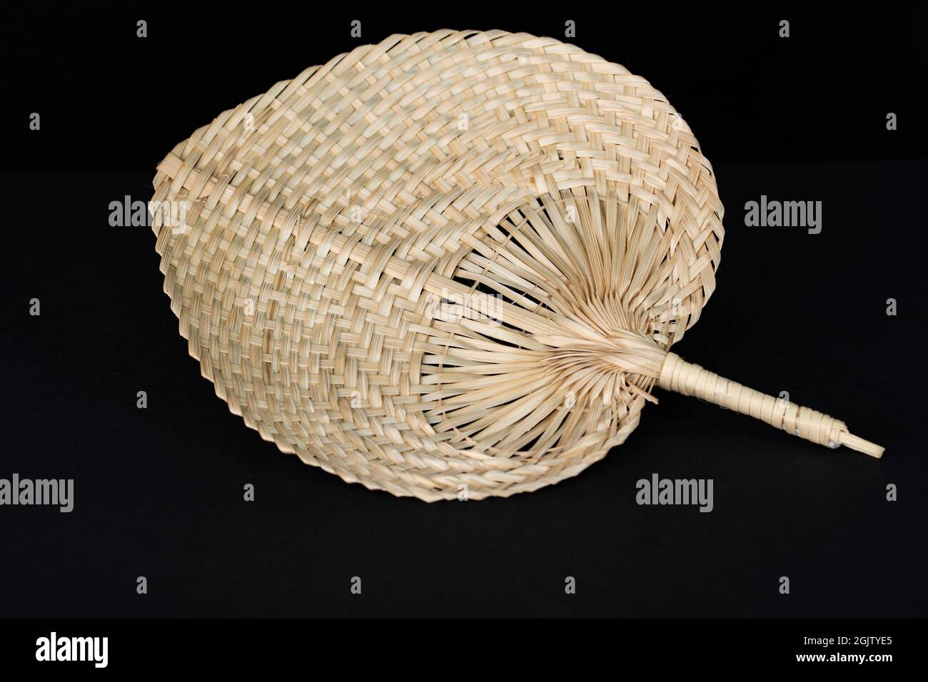 A beautiful hand fan made from screwpine leaves on black background ...