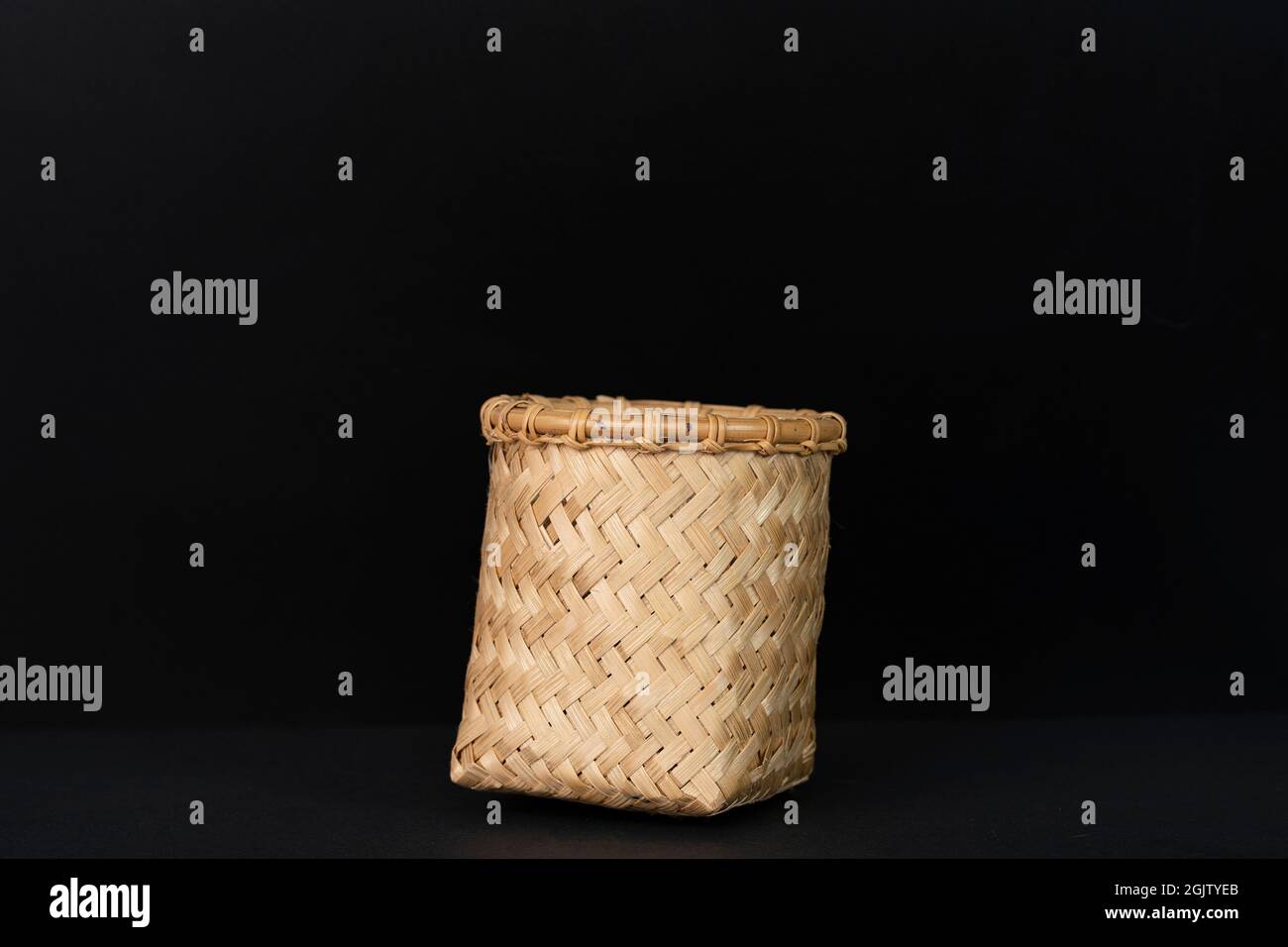 A beautiful container made from screwpine leaves on black background ...