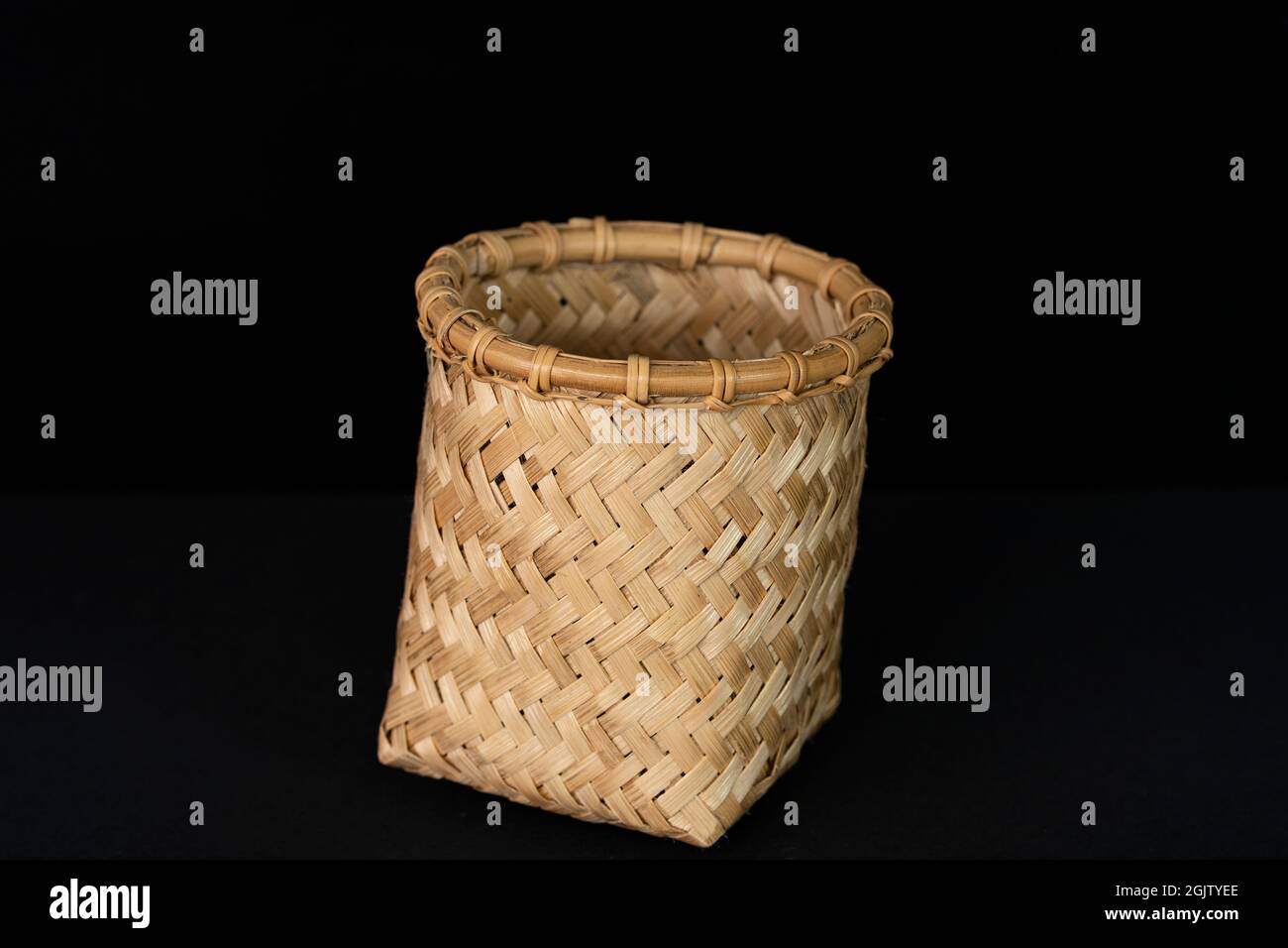 A beautiful container made from screwpine leaves on black background ...