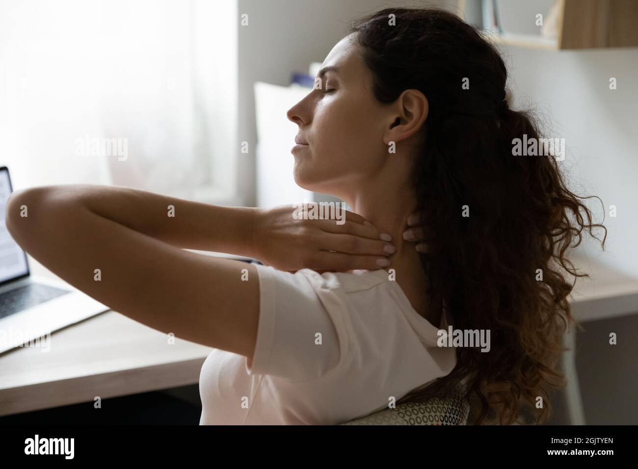 Woman touch stiff neck experiencing pain from long sedentary work Stock ...