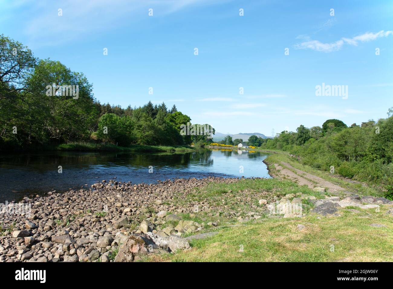 Peaceful river lined with trees on the left with a path on the right ...