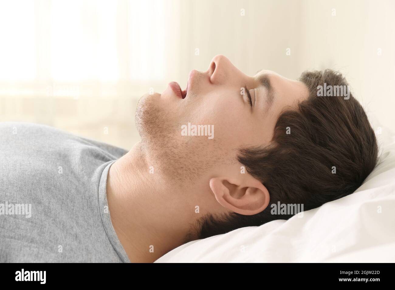 Handsome young man sleeping in bed at home Stock Photo - Alamy