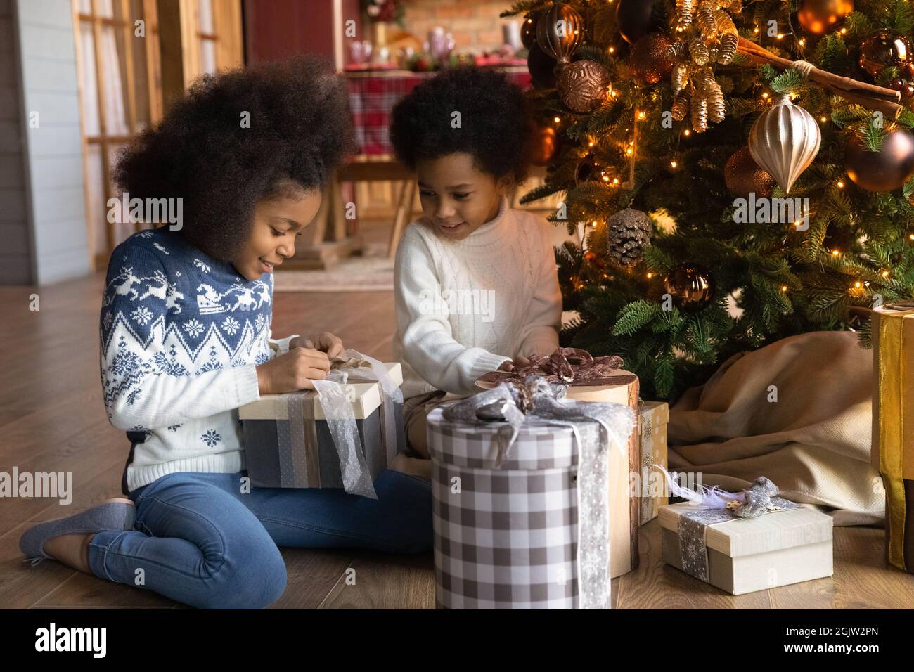 Boy girl open presents christmas tree hi-res stock photography and ...