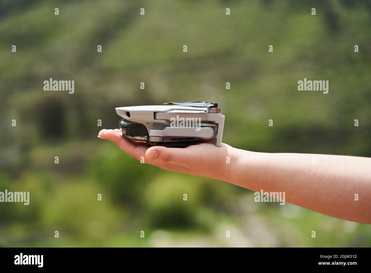 Modern small compact quadcopter in a girl's hand. Launching a drone ...