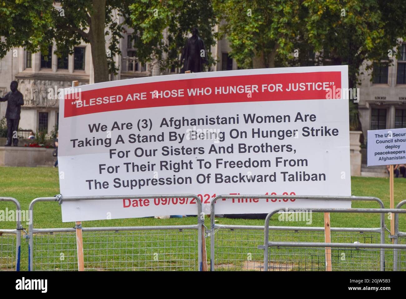 An information placard seen during the hunger strike. Three women are ...