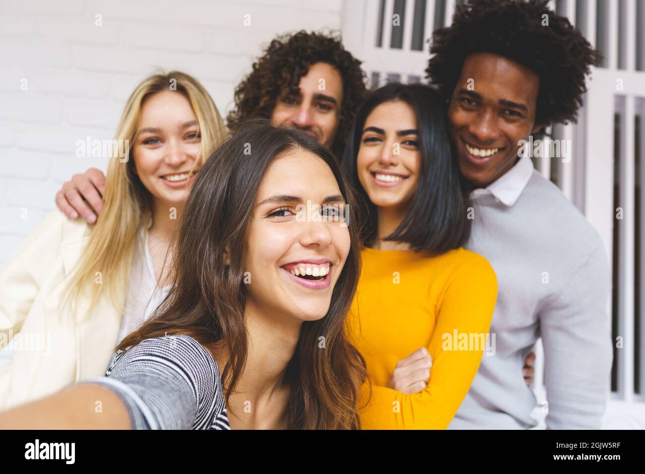 Multi-ethnic group of friends taking a selfie together while having fun ...