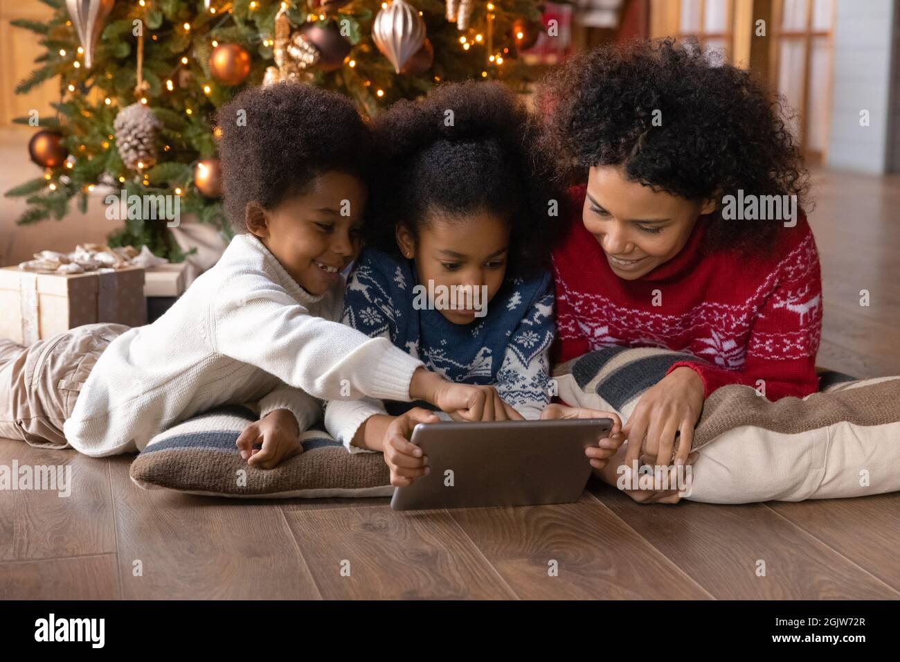 Happy ethnic mom and kids use tablet together Stock Photo - Alamy