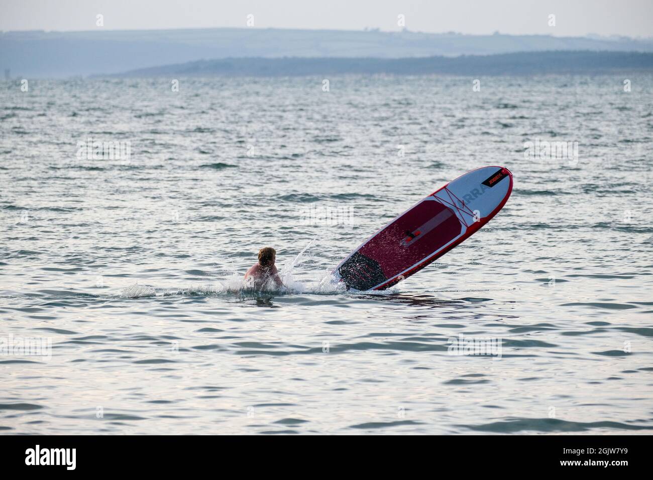A standup paddle board rider falls off his board into the sea at ...
