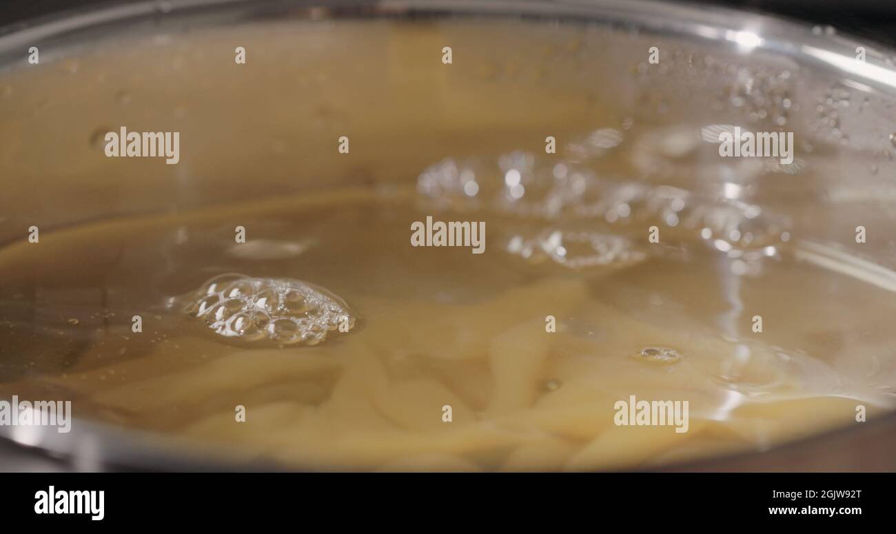 penne pasta in saucepan with boiling water, wide photo Stock Photo - Alamy