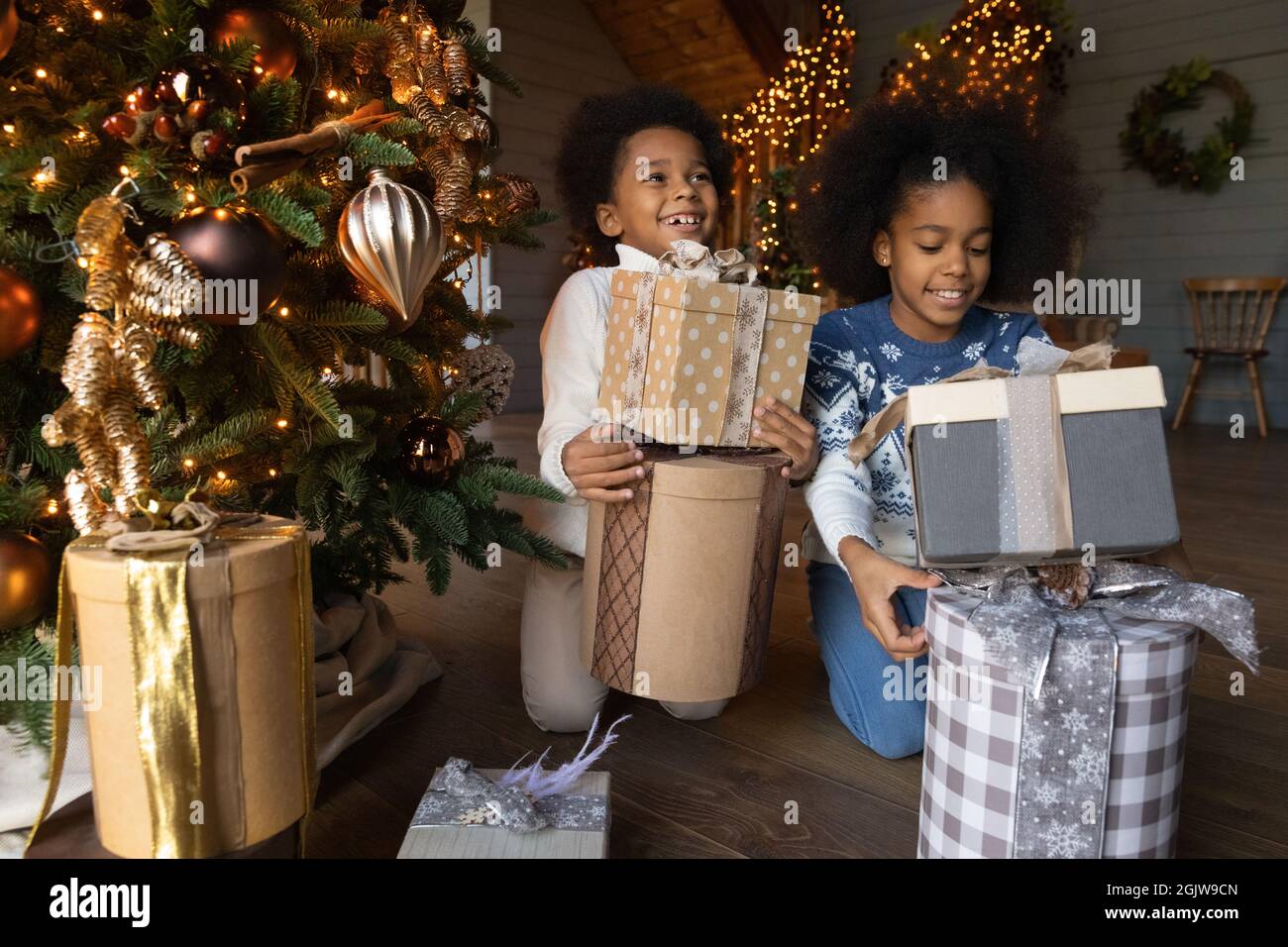 Happy biracial children unpack gifts on Christmas Stock Photo - Alamy