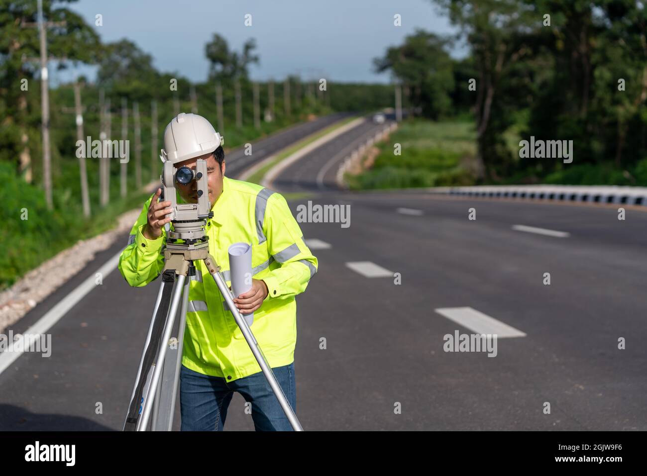 Asian surveyor engineer worker making measuring with theodolite on road ...