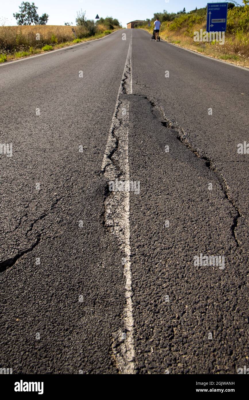 Close up of asphalt road surface crack with rural landscape in a ...