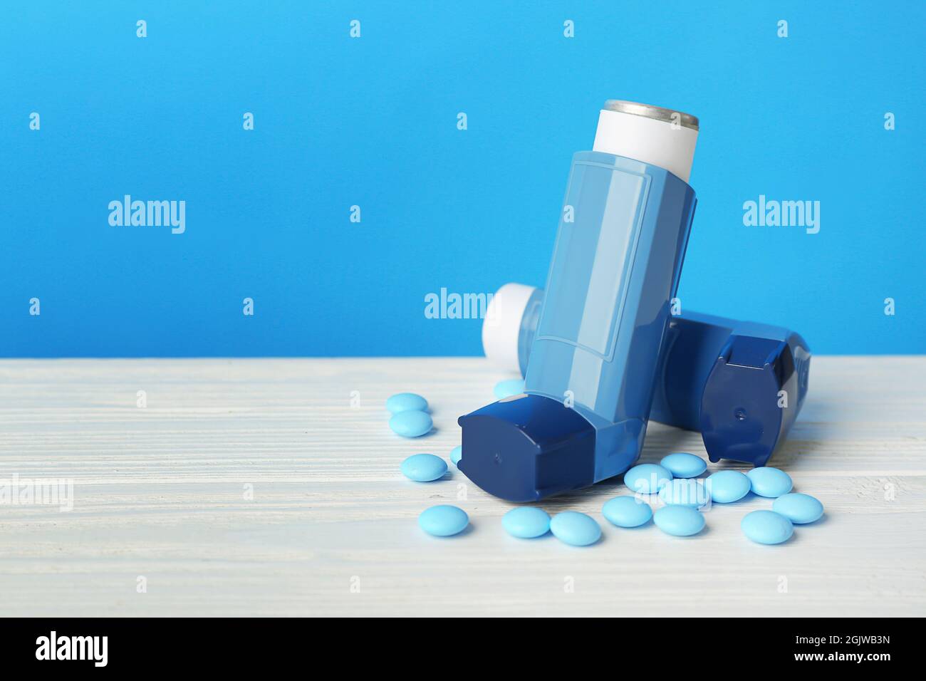 Asthma inhalers with medicine on blue background Stock Photo - Alamy