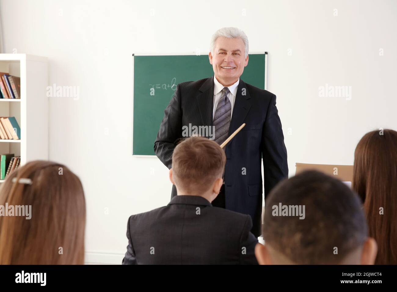 Pupils listening to teacher in classroom Stock Photo - Alamy