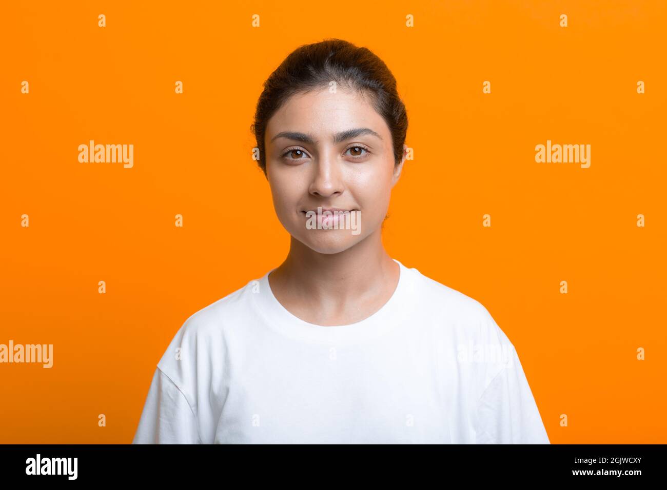 Portrait of positive smiling young adult indian woman in T-shirt orange ... Portrait of positive smiling young adult indian woman in T-shirt orange ...