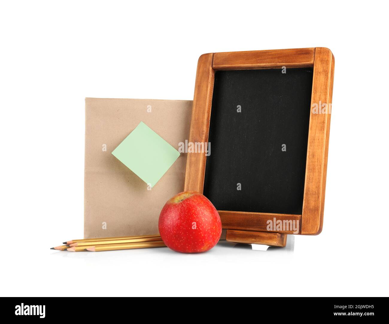 Blackboard, paper lunch bag with reminder and apple on white background ...