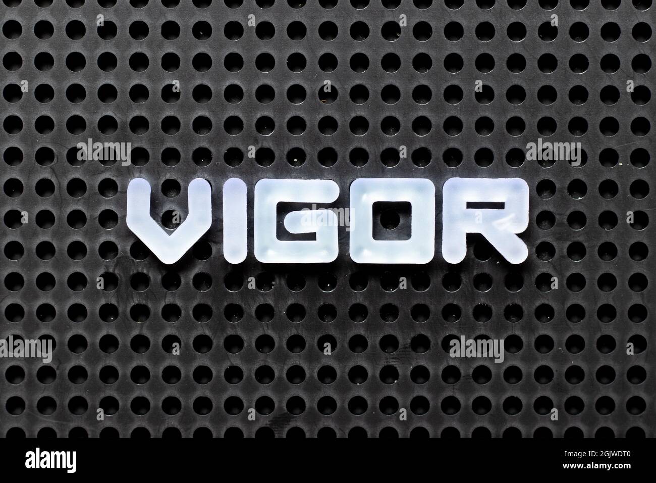 White color alphabet with word vigor on black pegboard background Stock ...