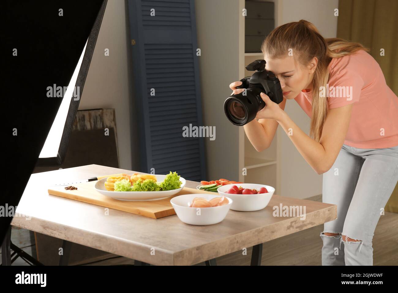 Young woman photographing food in photo studio Stock Photo - Alamy