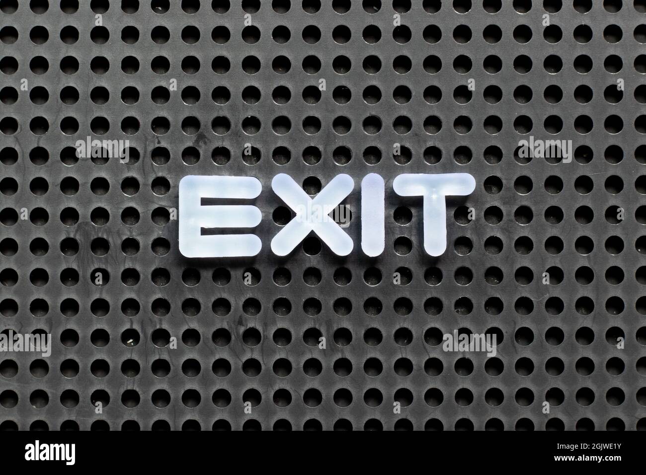 White color letter in word exit on black pegboard background Stock ...