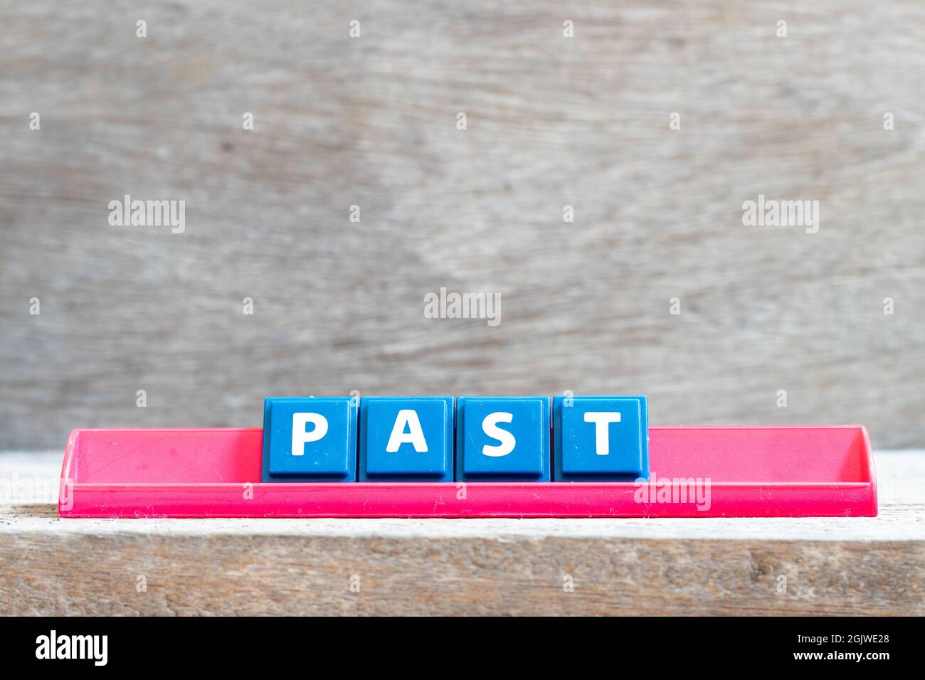 Tile letter on red rack in word past on wood background Stock Photo - Alamy