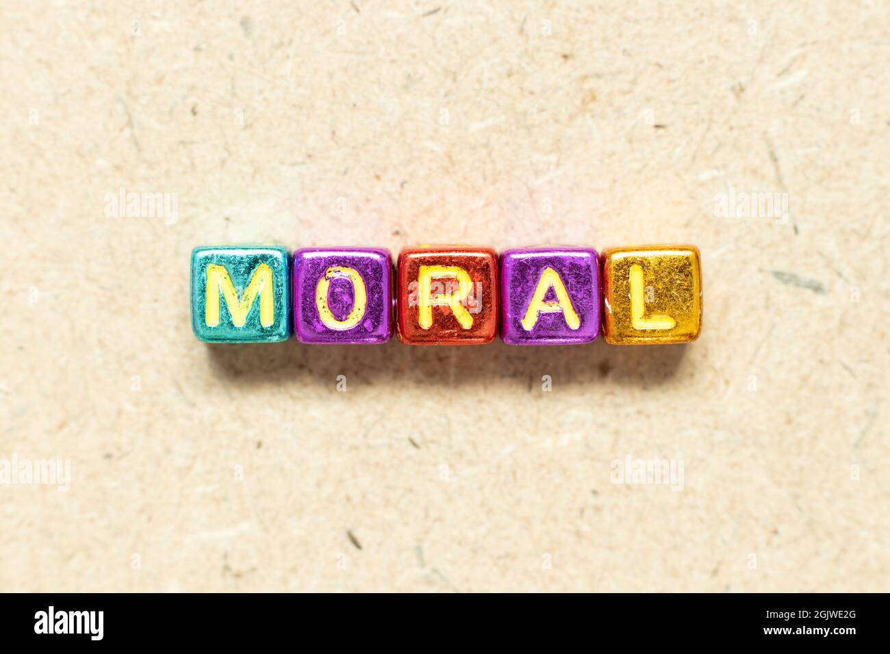 Metallic color alphabet letter block in word moral on wood background ...